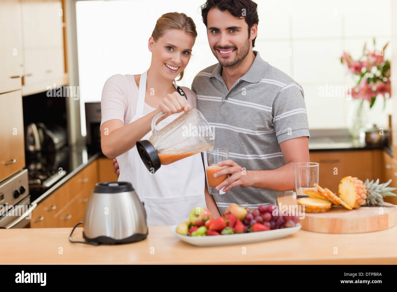 Young couple making fruits juice Stock Photo - Alamy