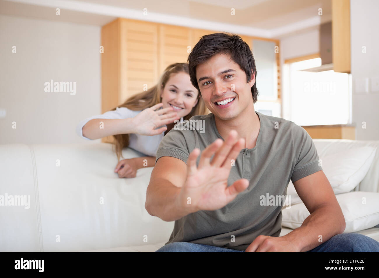 Couple waving at the camera Stock Photo - Alamy