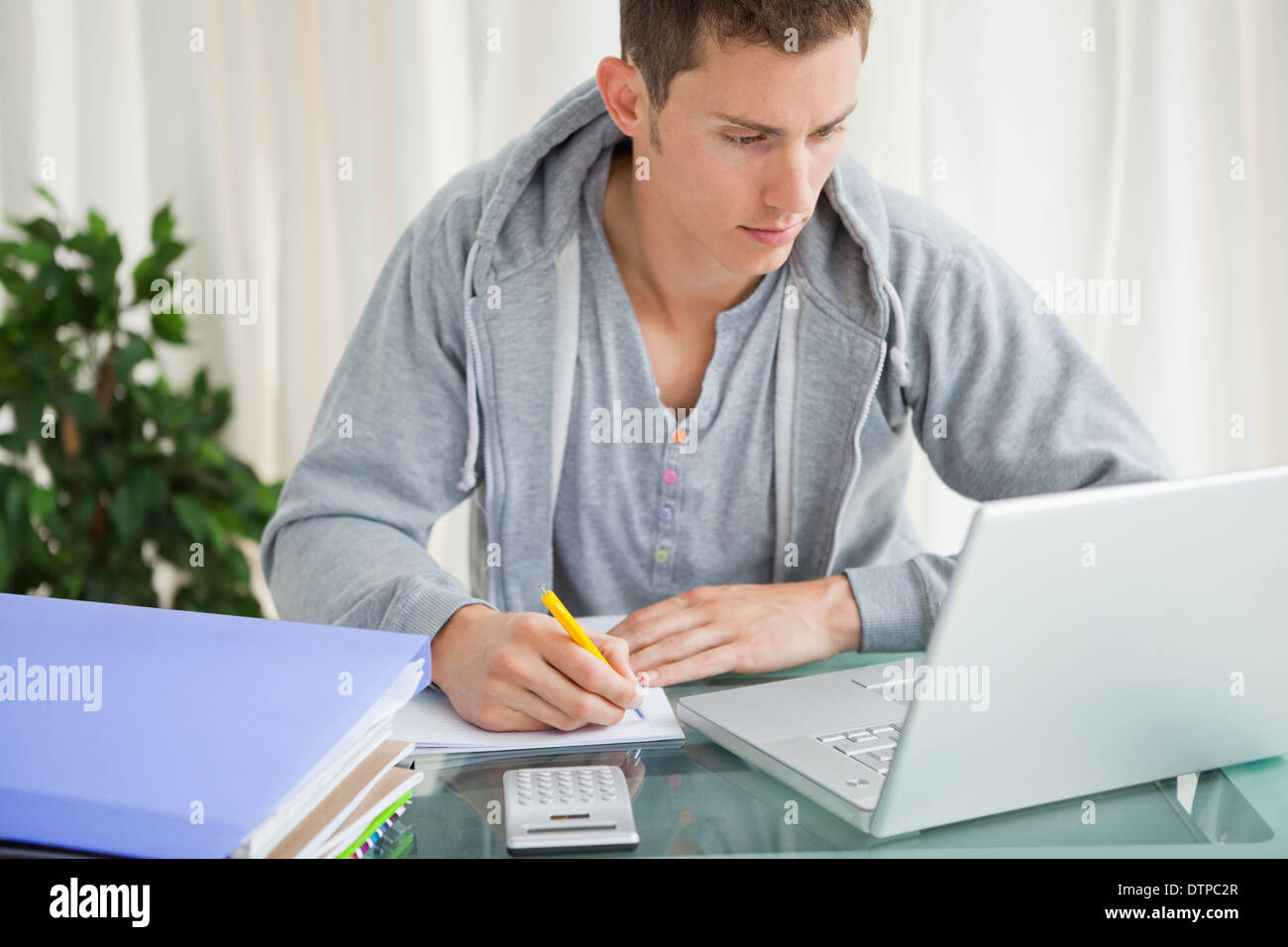 Student doing his homework with a laptop Stock Photo - Alamy