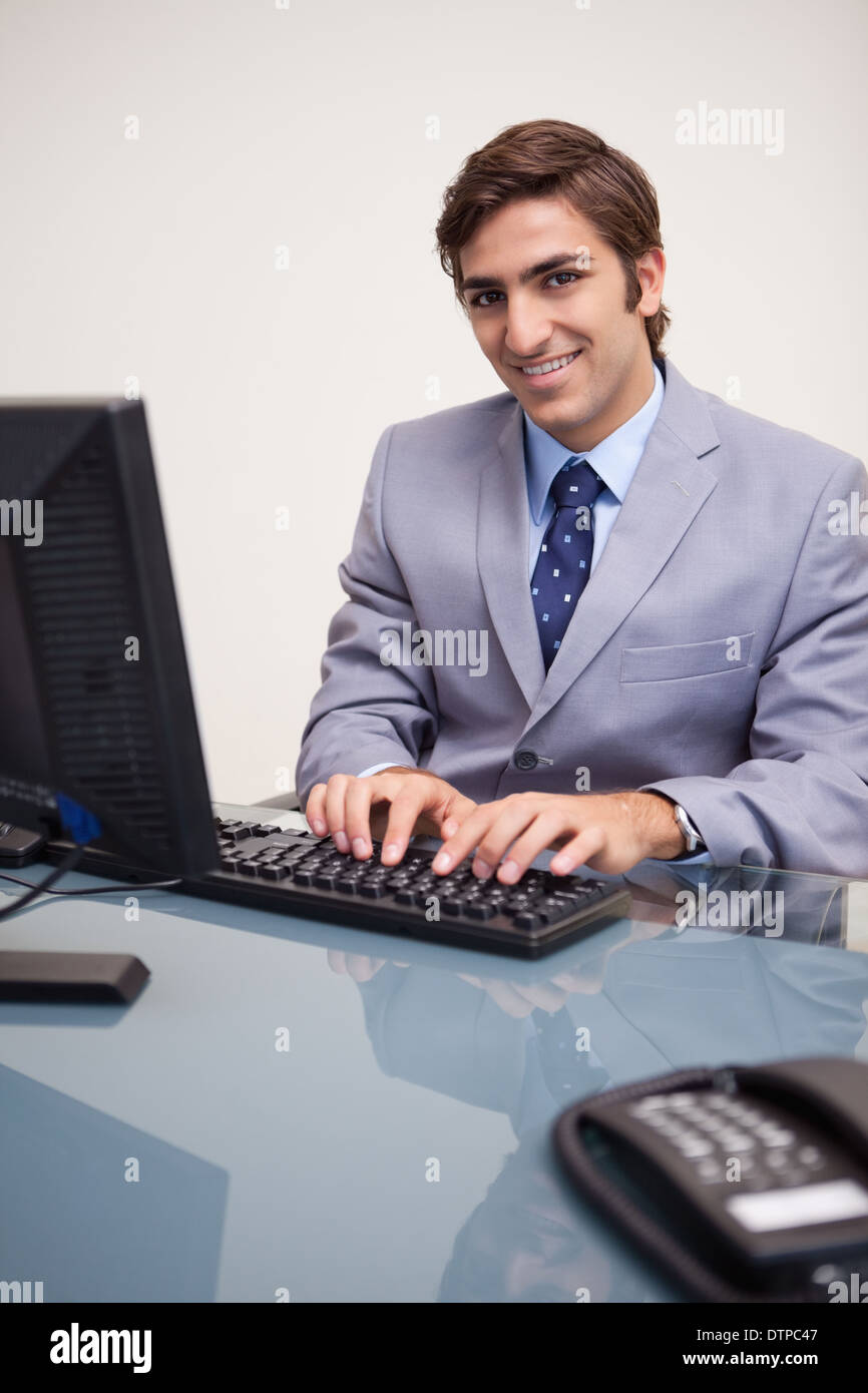 Smiling businessman typing on his keyboard Stock Photo - Alamy