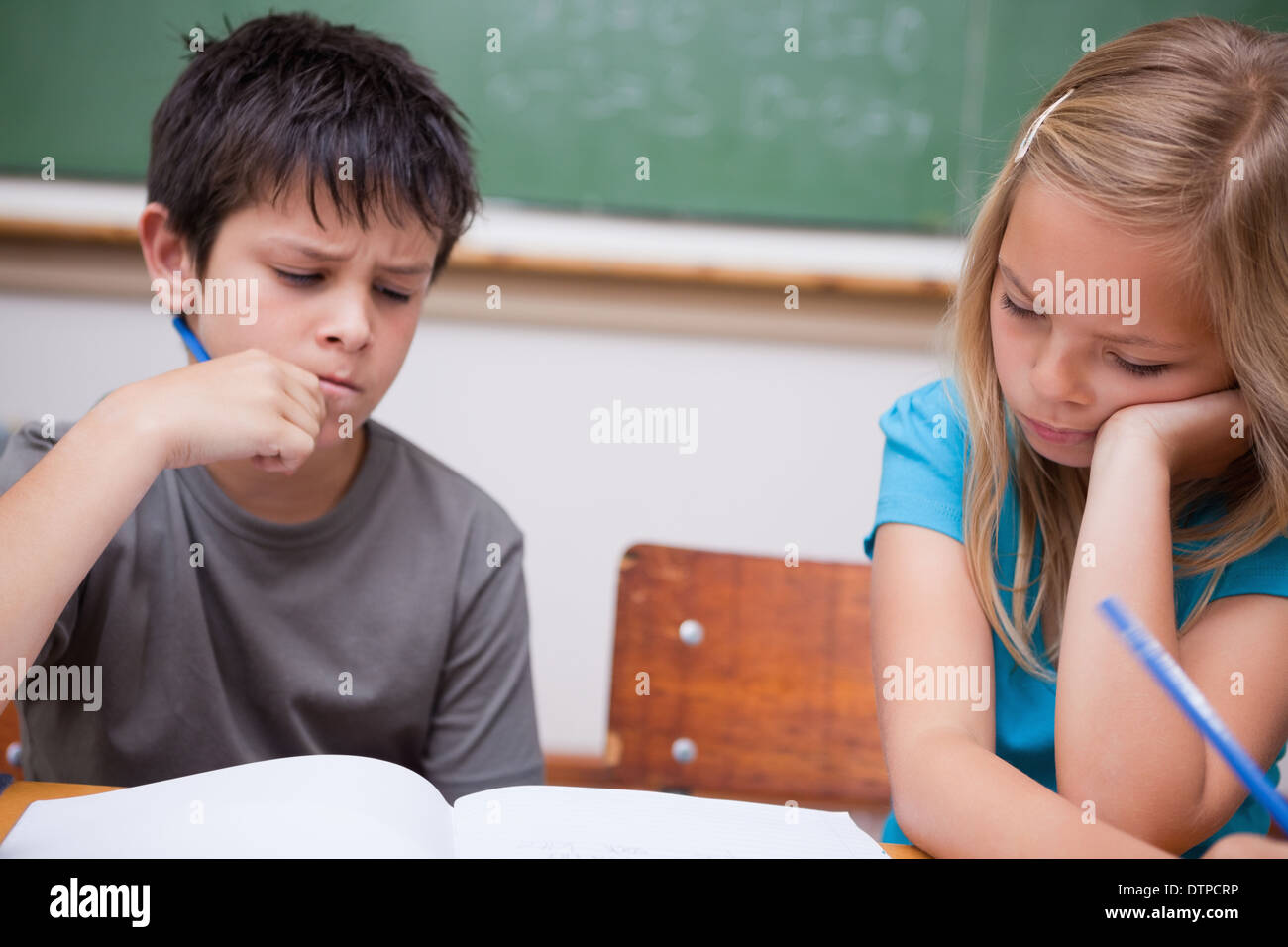 Thoughtful pupils working together Stock Photo - Alamy