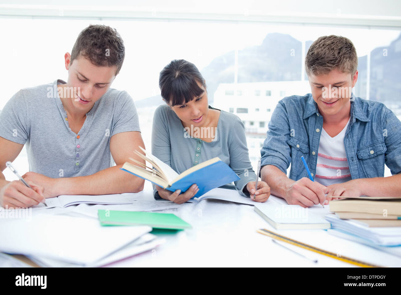 Three students study hard together Stock Photo - Alamy