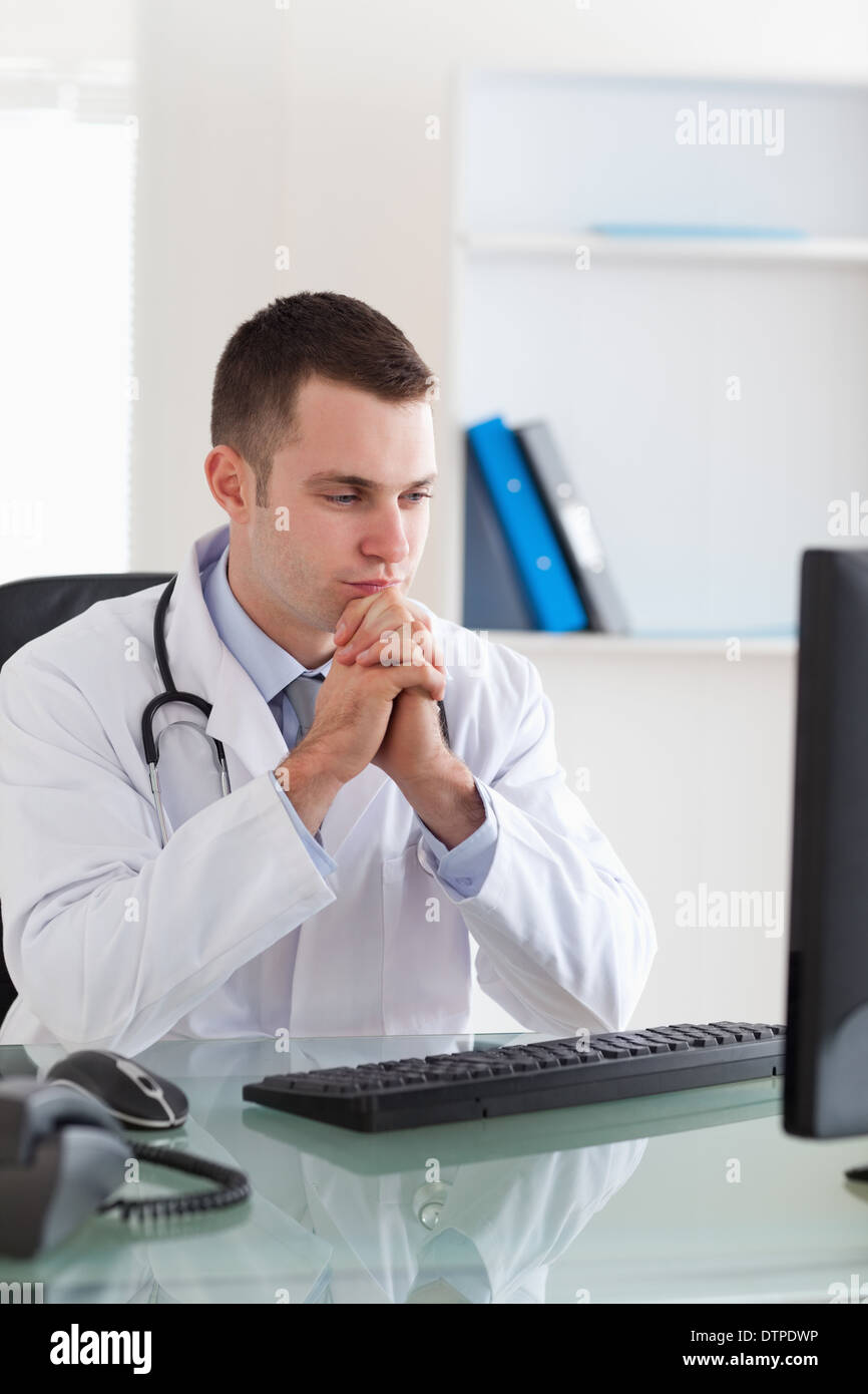 Doctor looking at computer screen Stock Photo - Alamy
