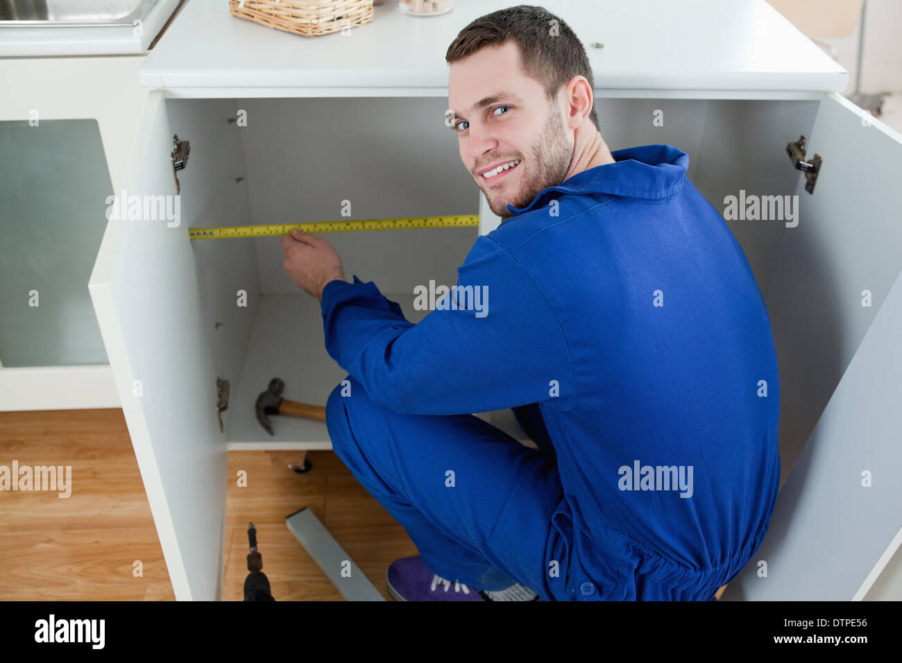 Smiling repair man measuring something Stock Photo - Alamy