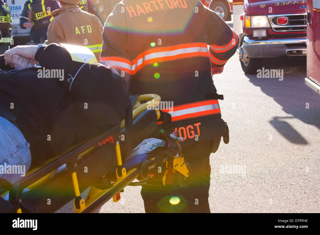 A Hartford firefighter pulling a stretcher with a victim to an ...