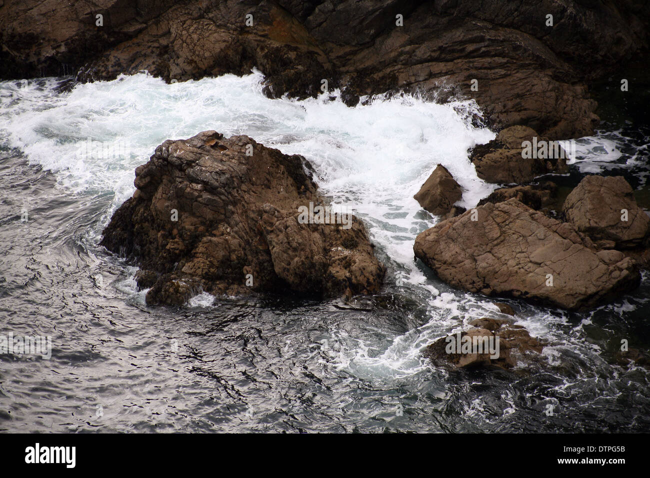 Ocean foam among the rocks Stock Photo - Alamy