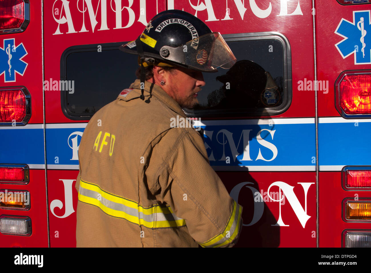 A firefighter in front of an ambulance Stock Photo - Alamy