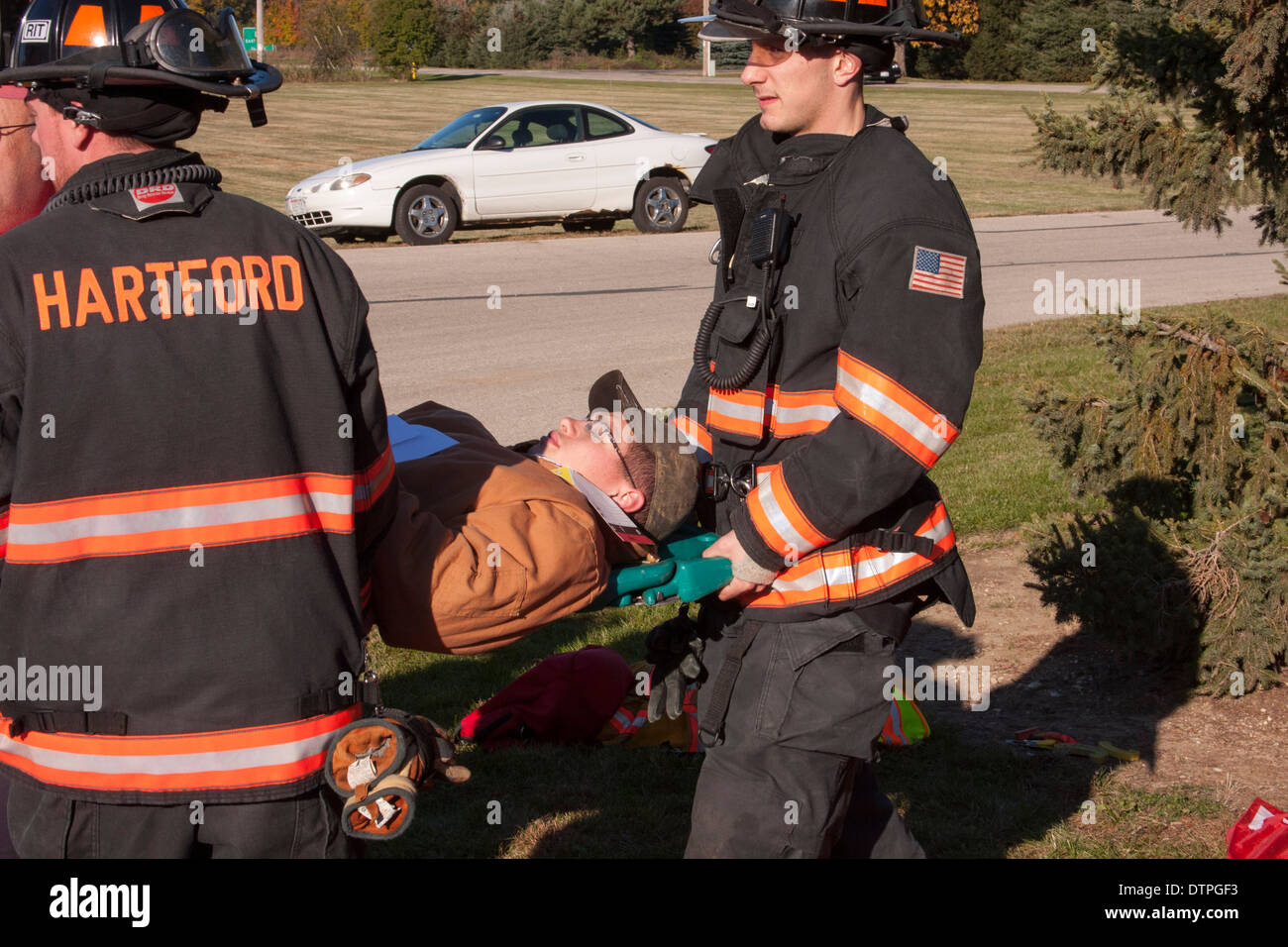 A mass casualty incident victim on a backboard being carried by EMTs ...