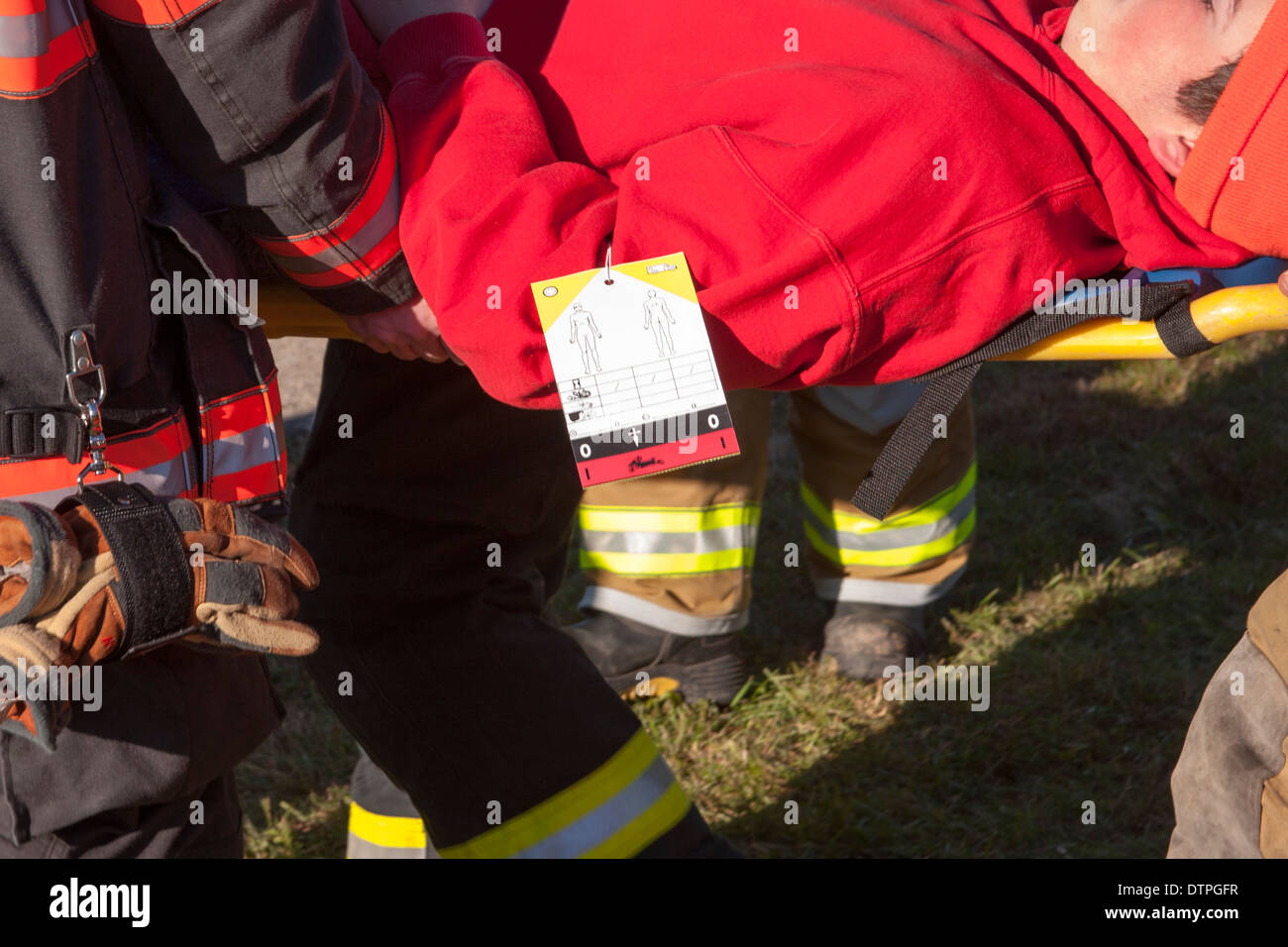 A mass casualty incident victim on a backboard being carried by EMTs ...