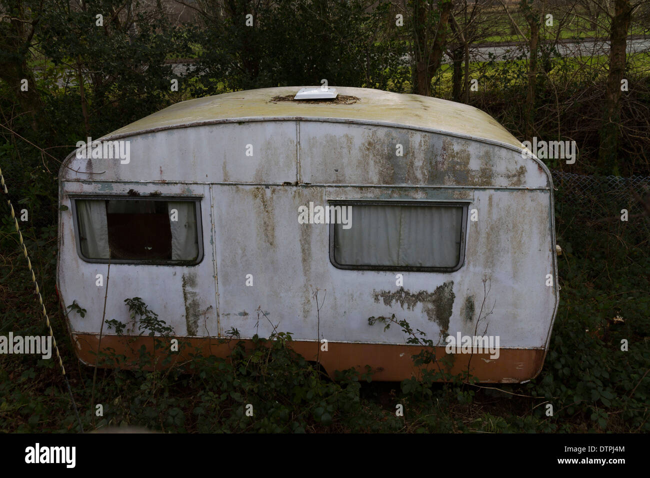 An abandoned caravan sitting in weeds Stock Photo - Alamy