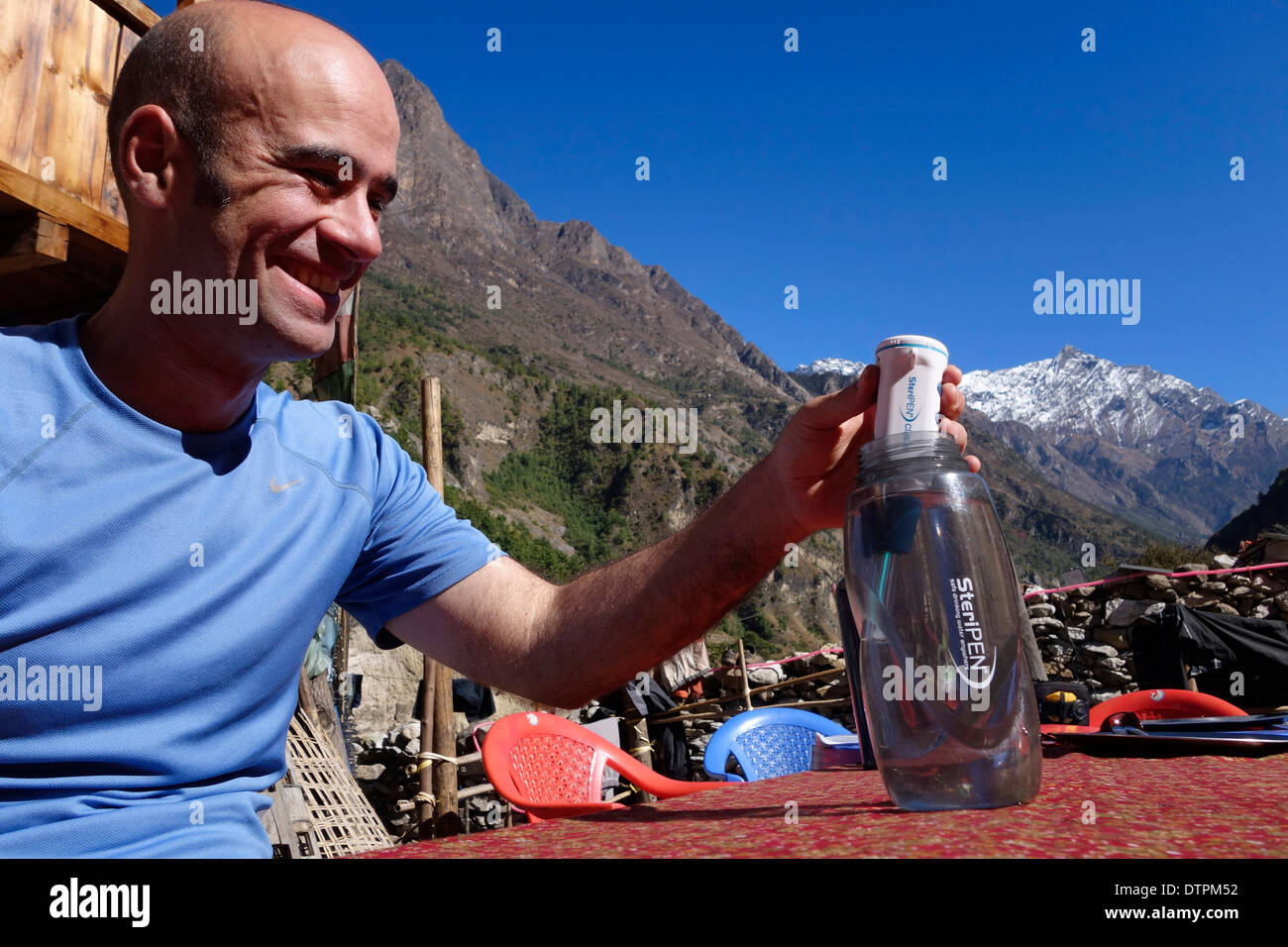 Trekker sterilizing water using a Steripen on a trek in the Himalayan ...