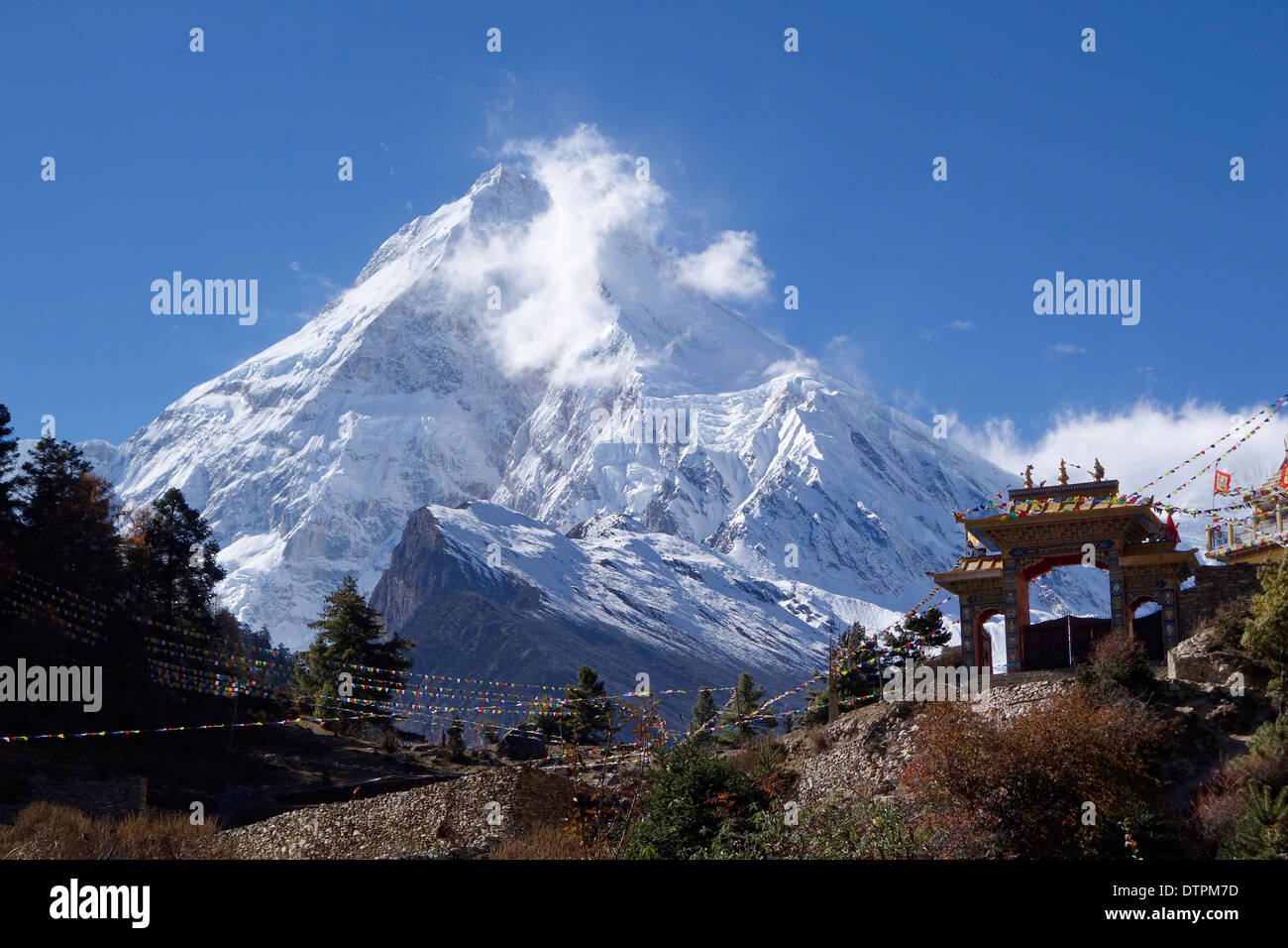 Manaslu peak looming over the new monastary in Lho, Nepal Stock Photo ...