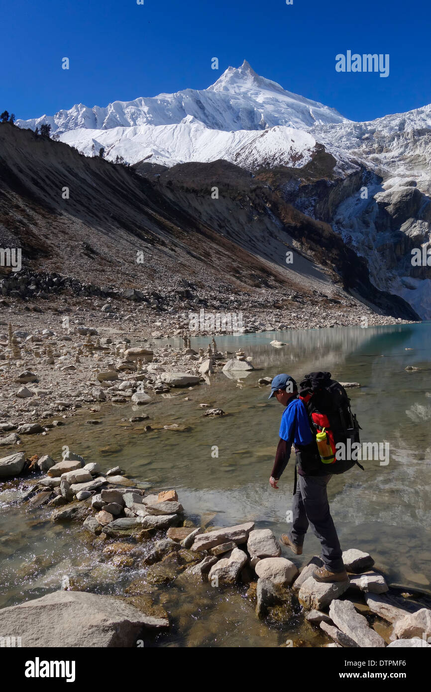 Trekker crossing the outlet of Birendra Tal (Lake Birendra), Nepal ...