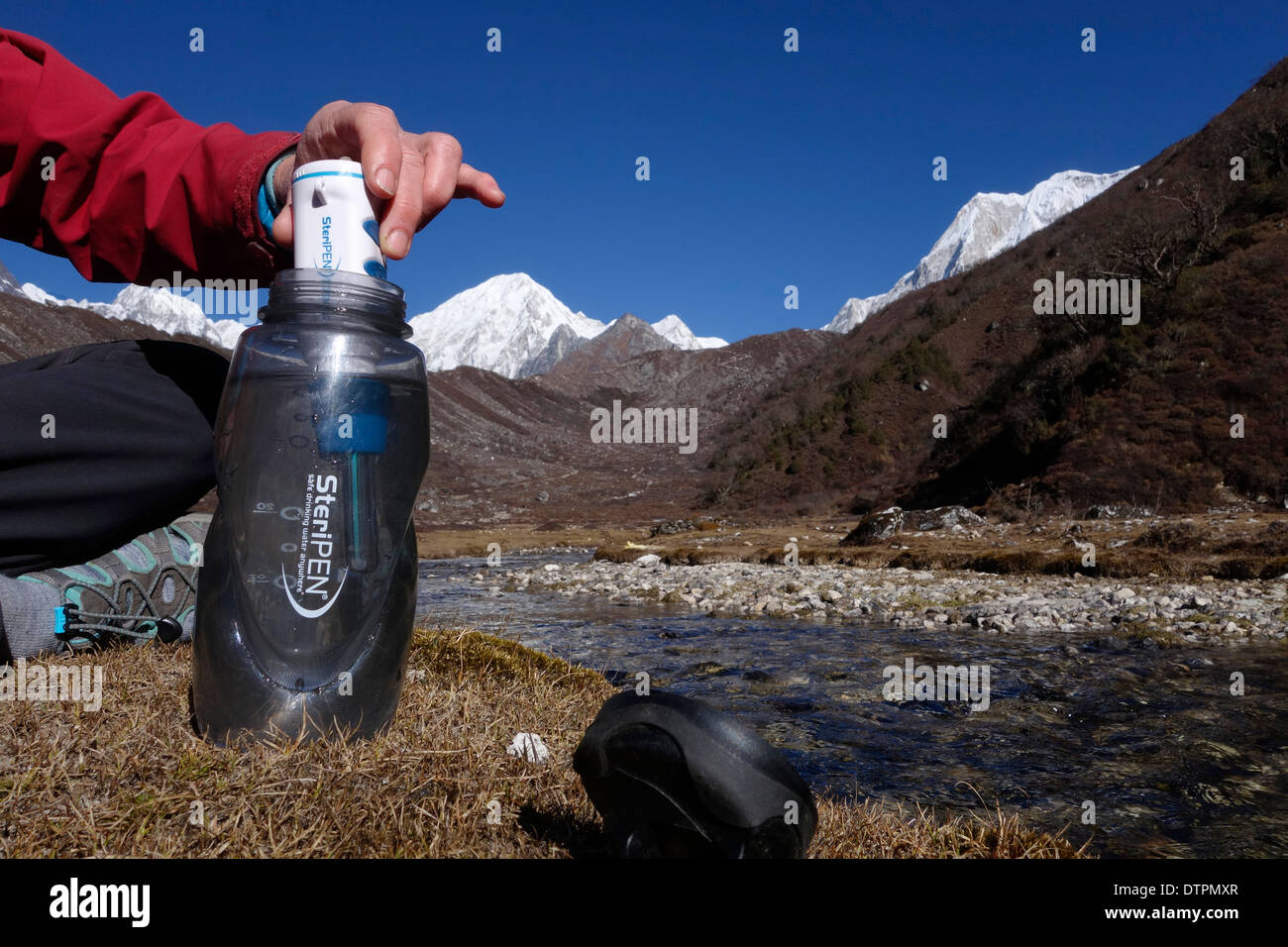 Trekker sterilizing water using a Steripen on a trek in the Himalayan ...