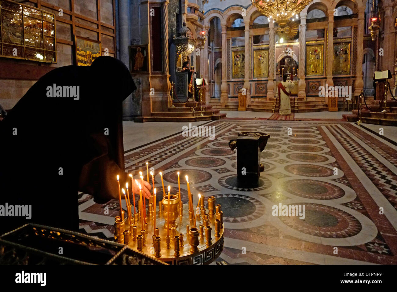 A Christian worshiper lights candles during a procession inside the ...