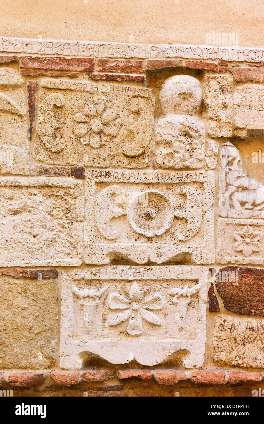 Roman and Etruscan stone carving reliefs inset to the wall of Palazzo ...