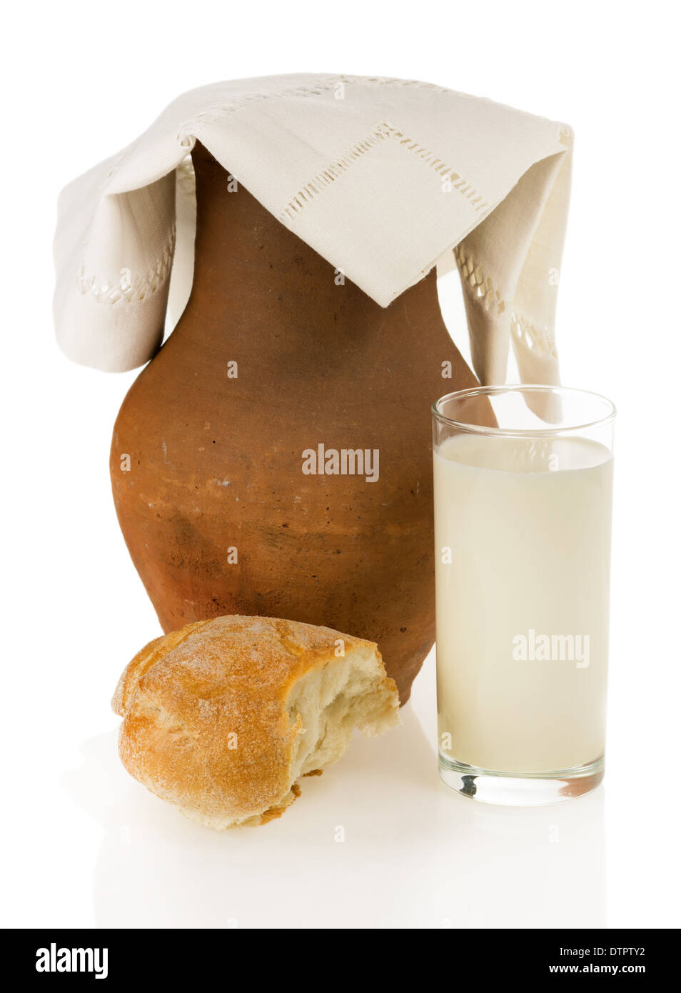 Old clay jug, bread and a glass of milk on a white background Stock ...