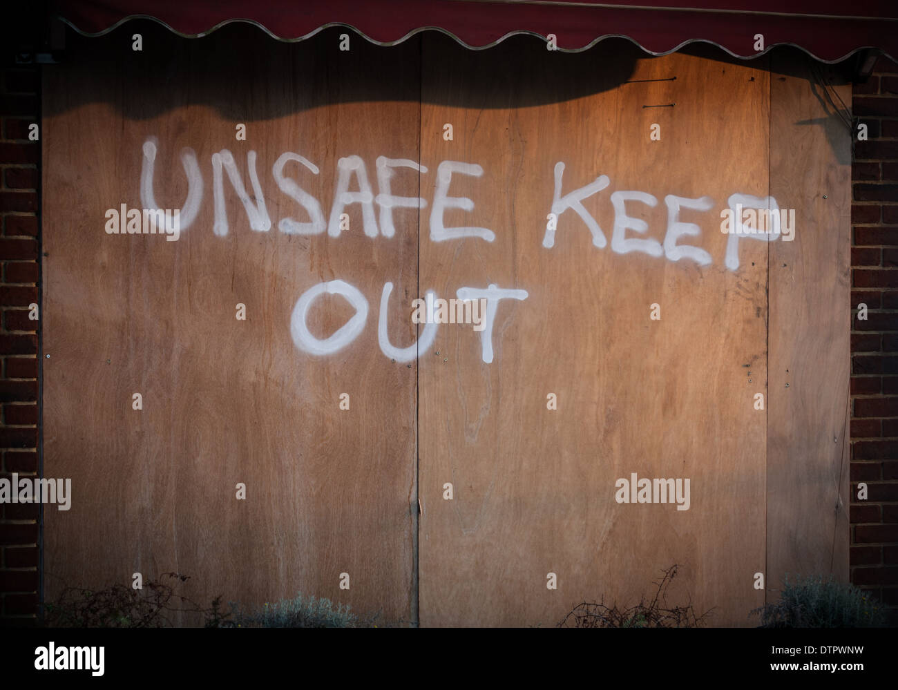 Hand written warning sign that says "Unsafe Keep Out Stock Photo - Alamy