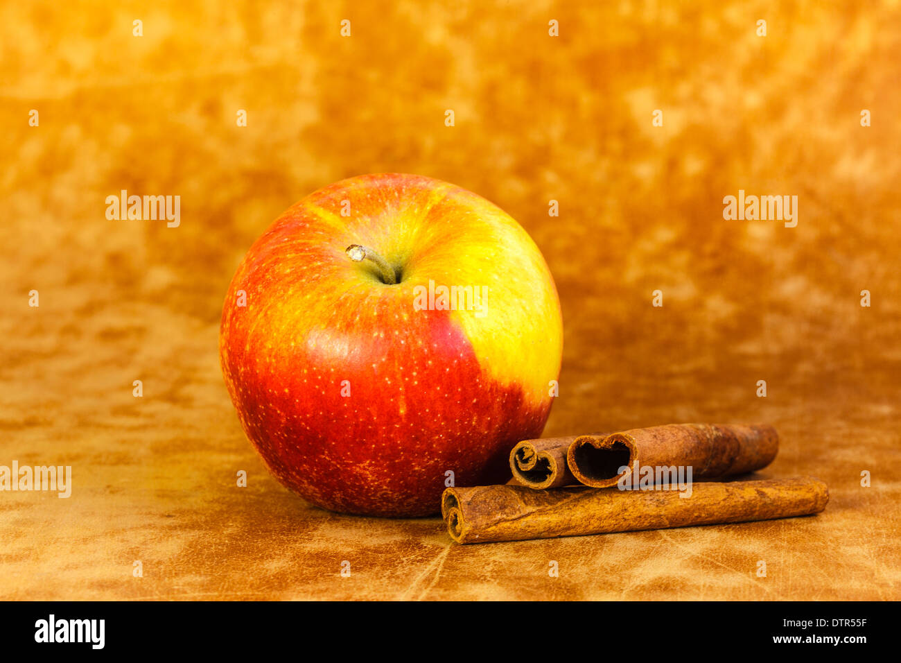 Apple with cinnamon on a rustic background Stock Photo - Alamy