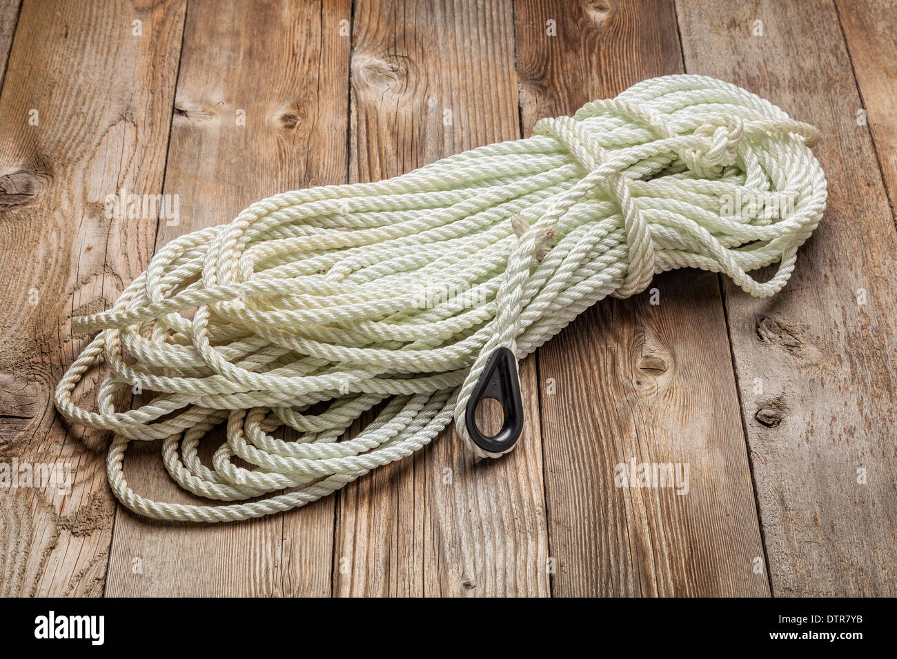 coiled anchor white nylon rope on a wooden deck Stock Photo - Alamy