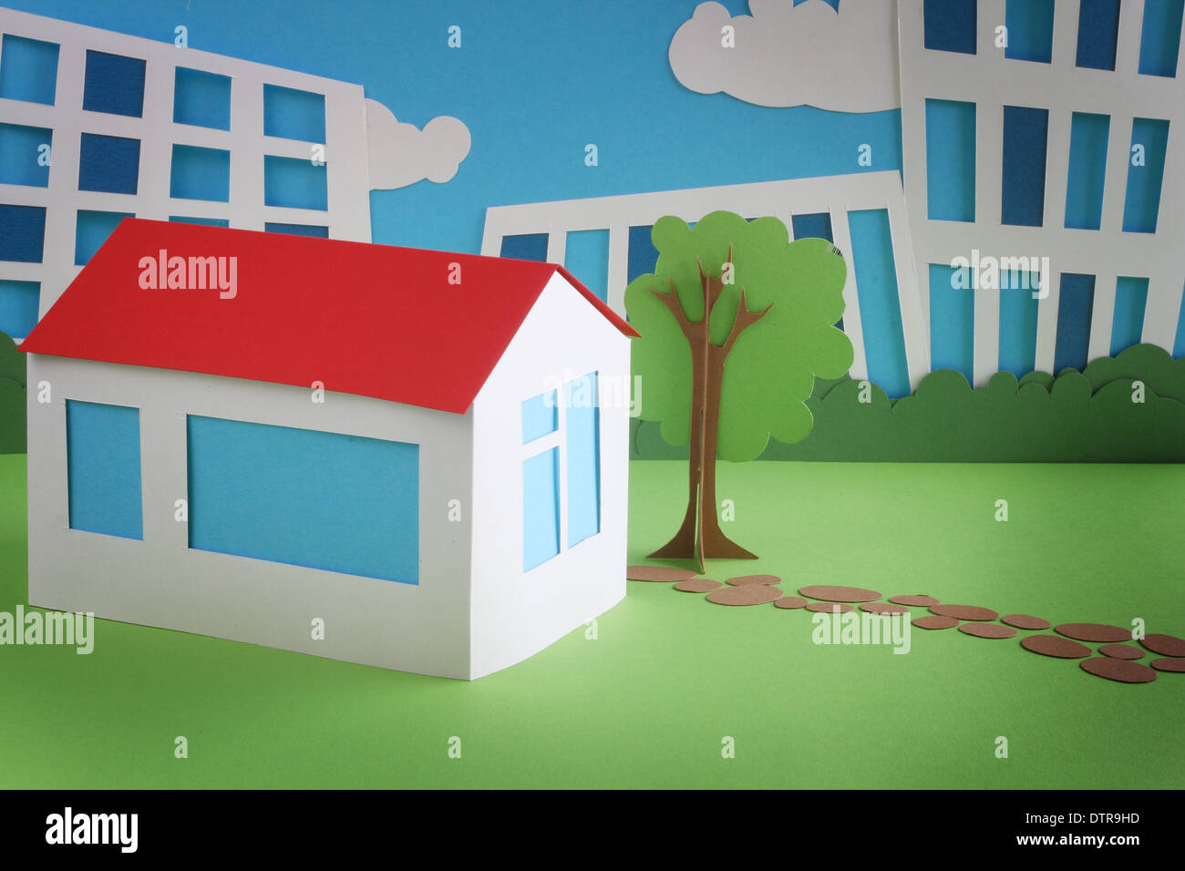 Paper cottage over city background real estate concept Stock Photo - Alamy