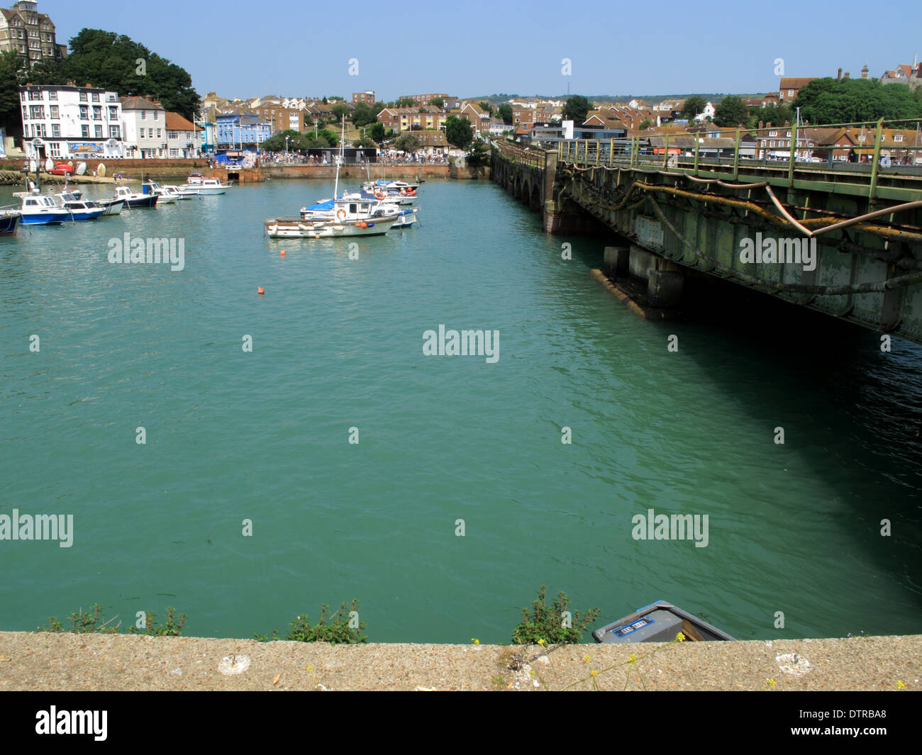 A landscape view showing the old boats and a bridge at Folkestone ...