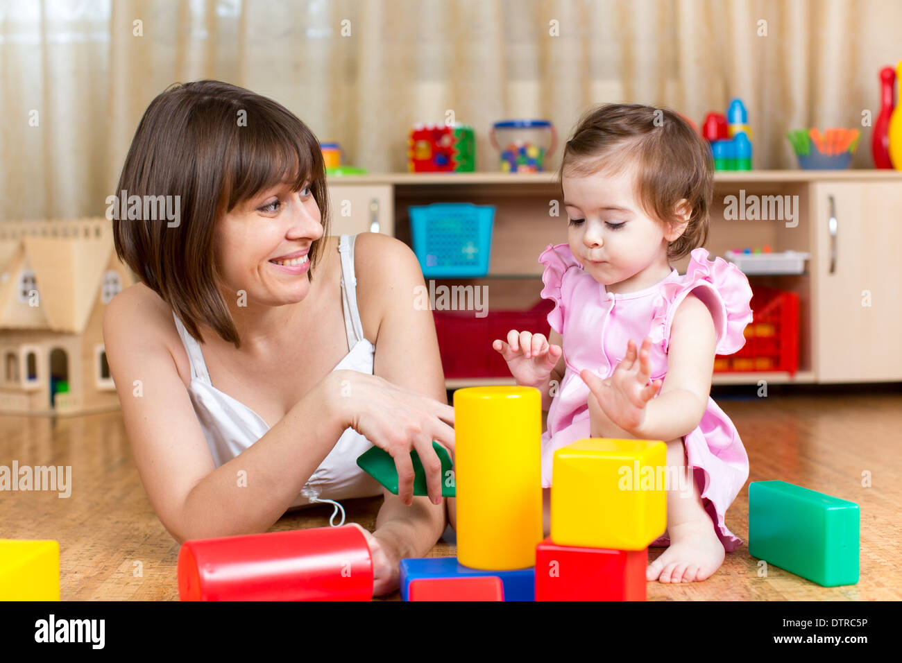 mom and kid play toys indoors Stock Photo - Alamy