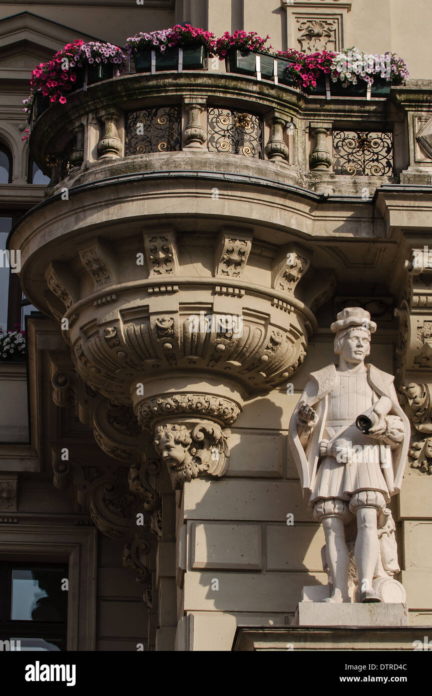 A statue and a balcony with flowers in the facade of the Townhall of ...