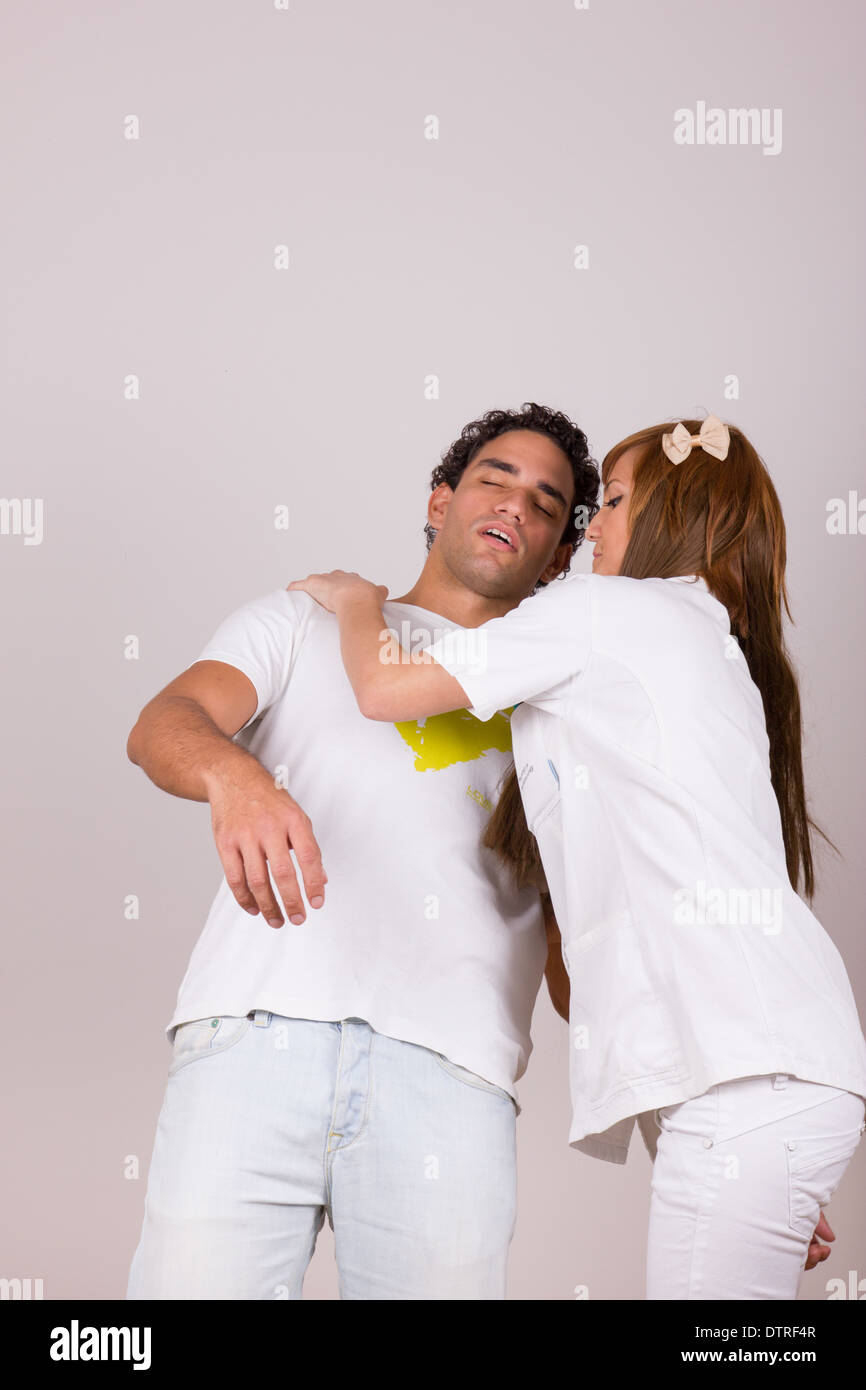 professional nurse holding sick fainting man, studio isolated on white ...