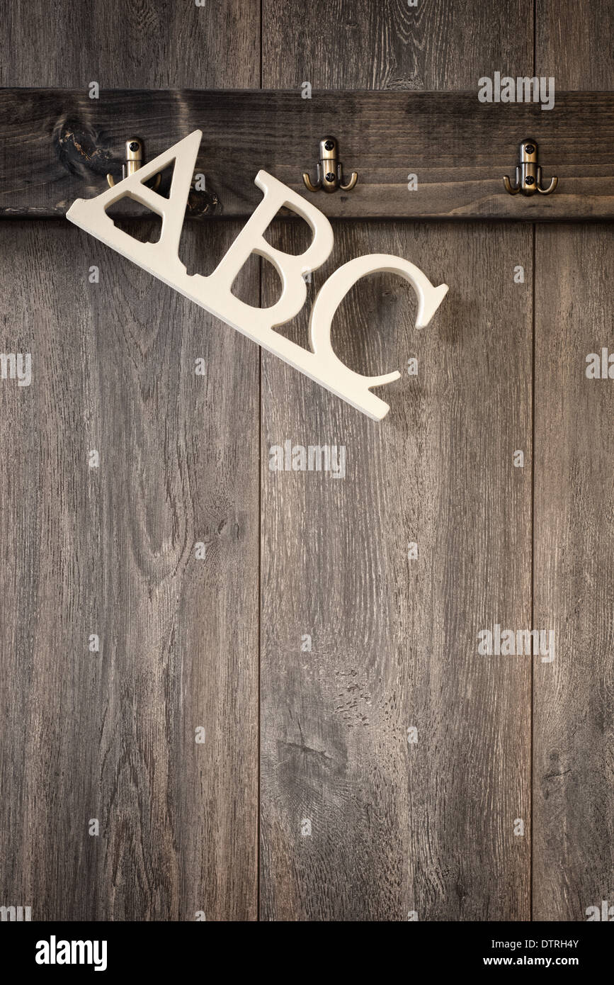 ABC letters hanging from hook on panelled wall Stock Photo - Alamy