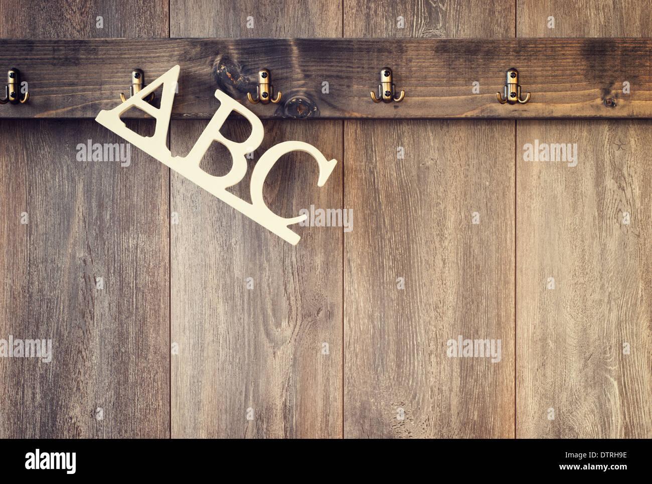 ABC letters hanging from hook on panelled wall Stock Photo - Alamy