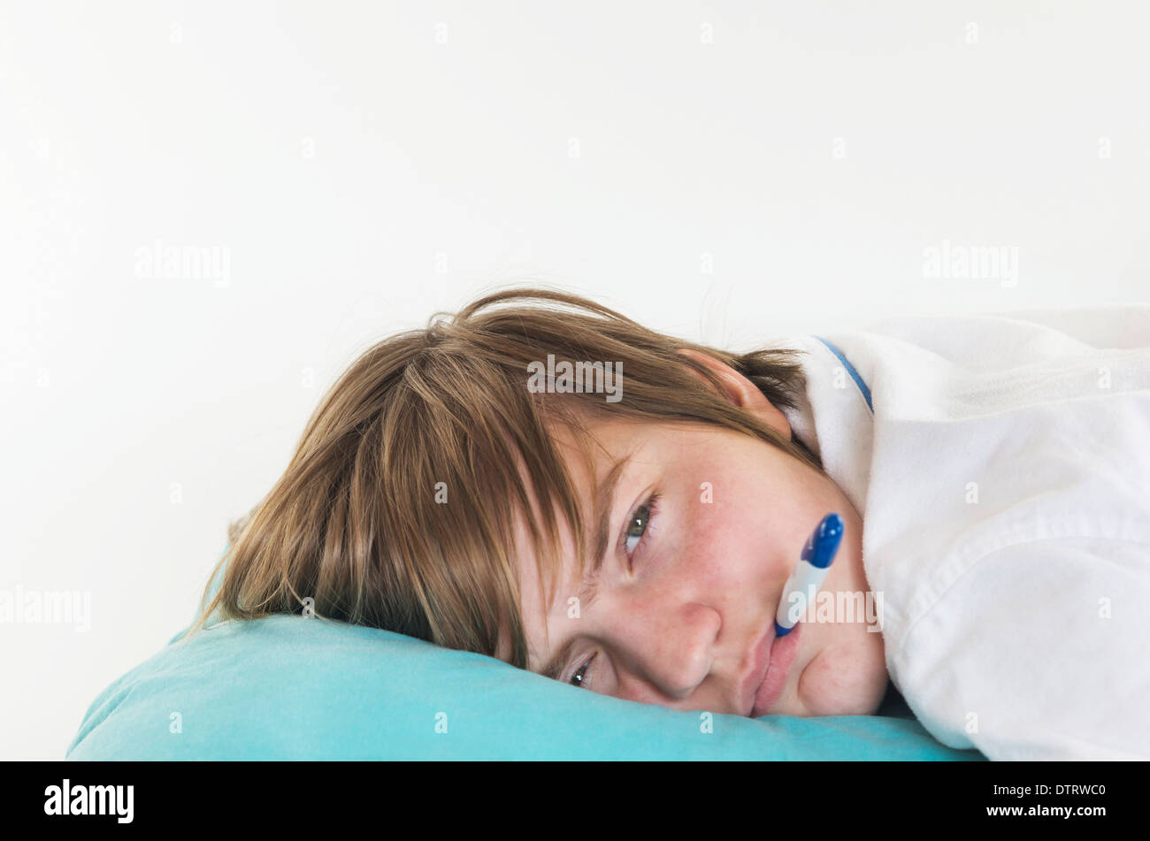 Sick girl getting her temperature taken, head on pillow Stock Photo - Alamy