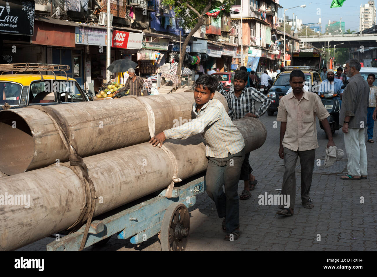 Young man pushing hand cart in old Mumbia near the JJ Flyover. These ...