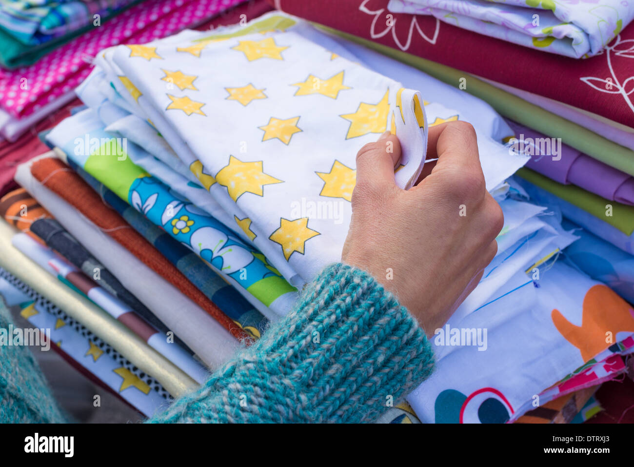 Female hand rummaging among fabrics on a market stall Stock Photo - Alamy