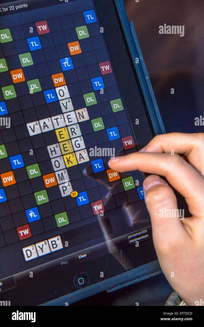 hand with ipad playing wordgame Stock Photo - Alamy