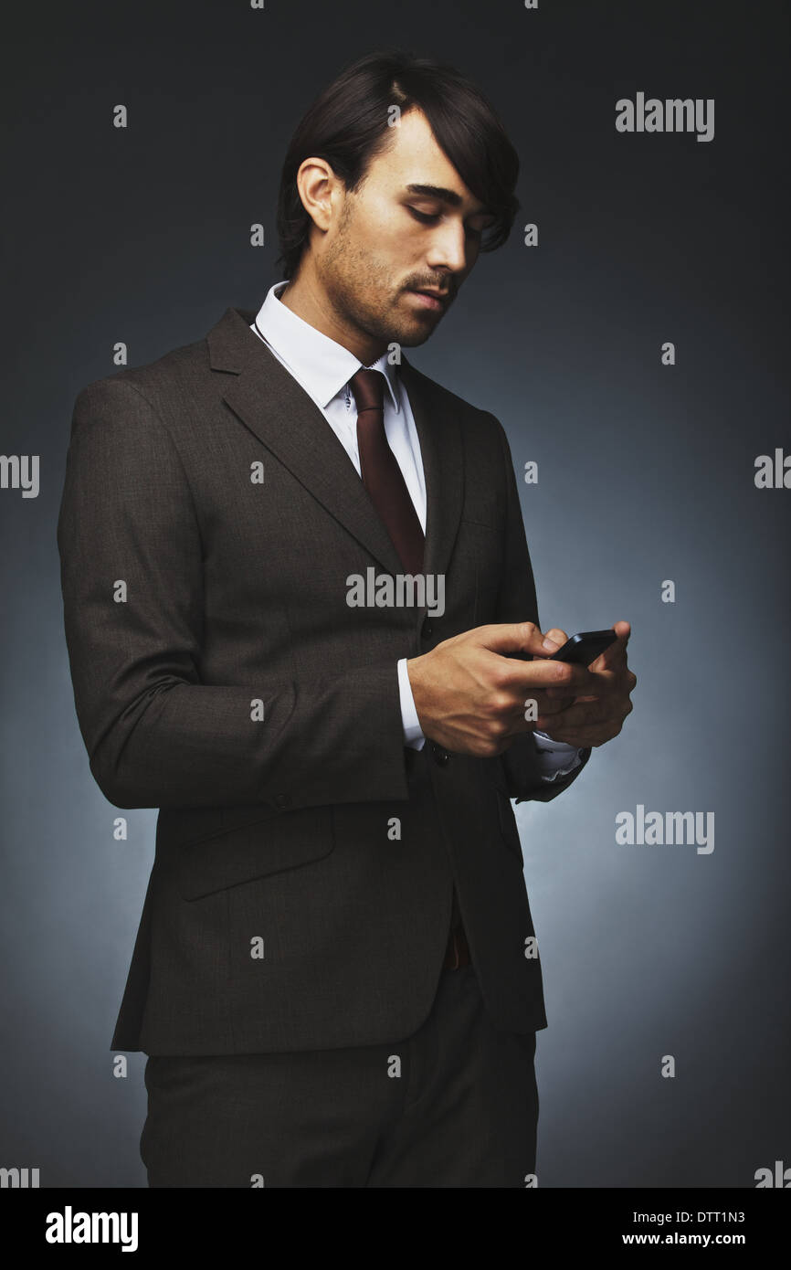 Handsome young business man texting on his phone. Male executive ...