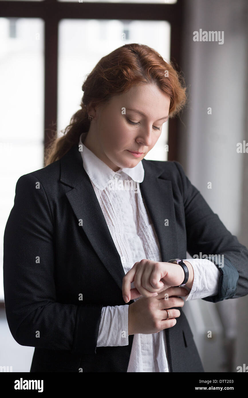 Business woman check time with watch in office Stock Photo - Alamy