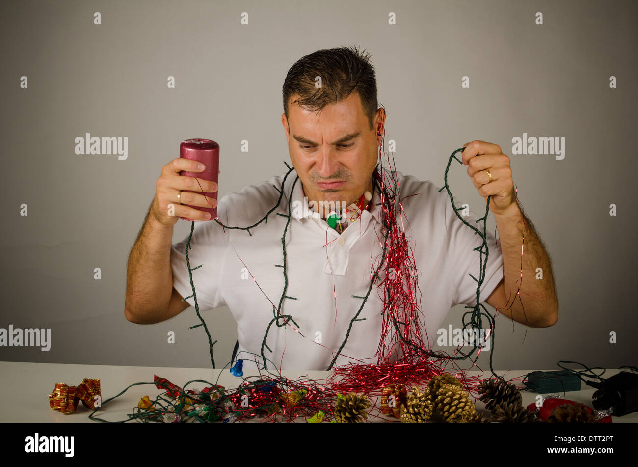Guy struggling with a mess of party decoration Stock Photo - Alamy