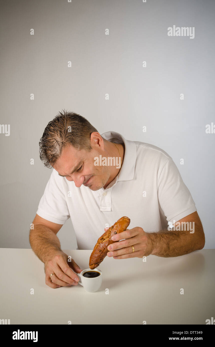 Guy having trouble to dunk his breakfast roll Stock Photo - Alamy
