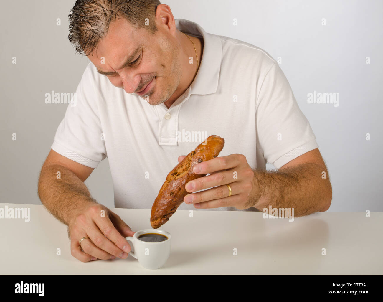 Guy having trouble to dunk his breakfast roll Stock Photo - Alamy