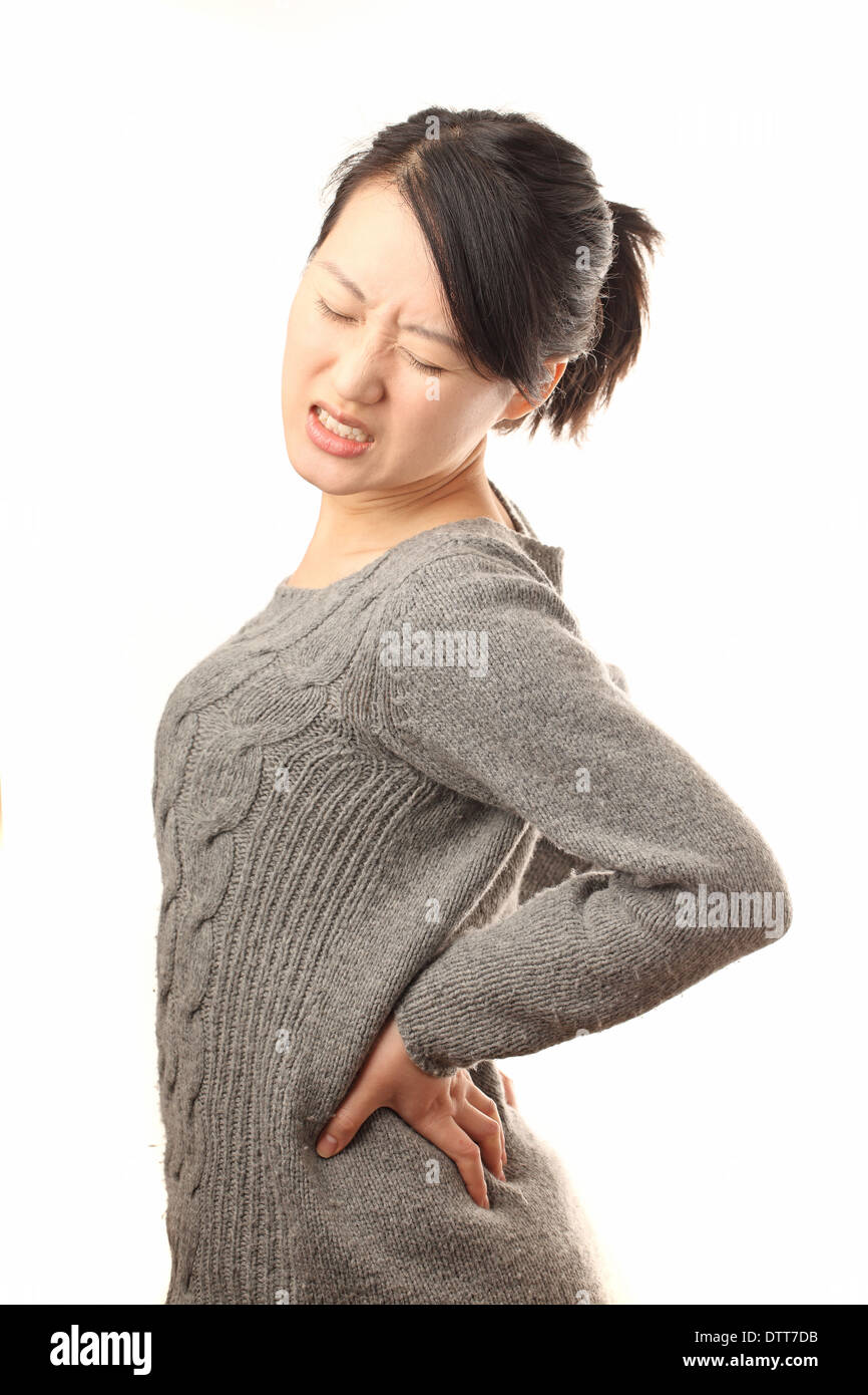 Asian woman with back pain on white background Stock Photo - Alamy