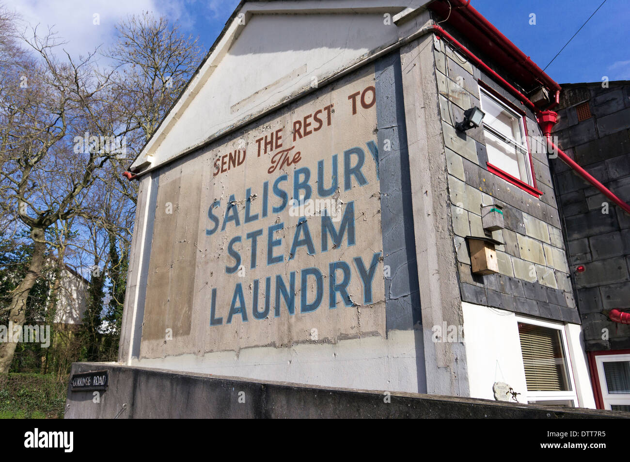 Old fashioned hand painted advertising sign on the side of a UK house ...