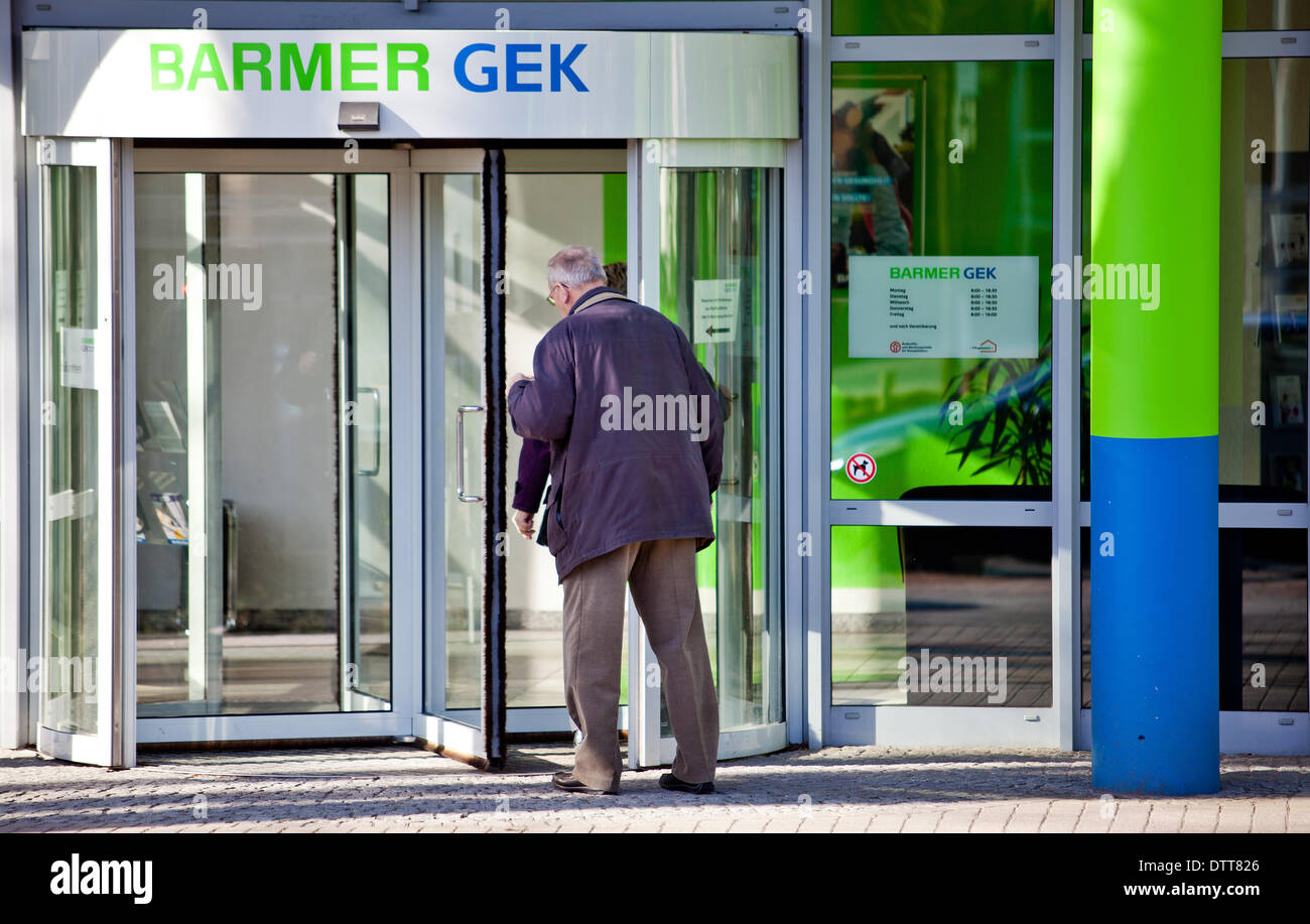 A man and a woman walk through the entrance of a Barmer GEK location in ...