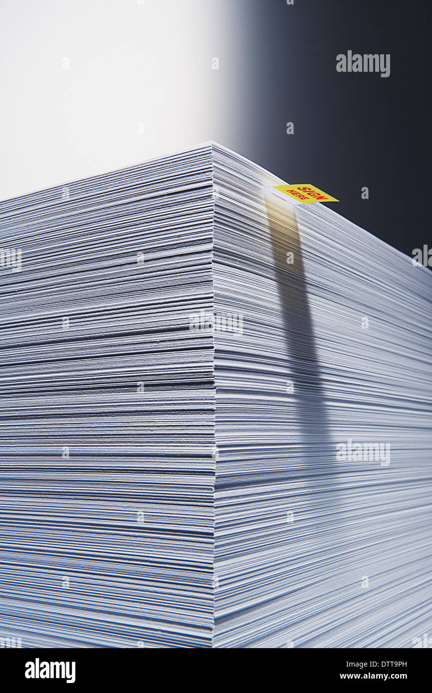 Sign here tab on stack of paper Stock Photo - Alamy