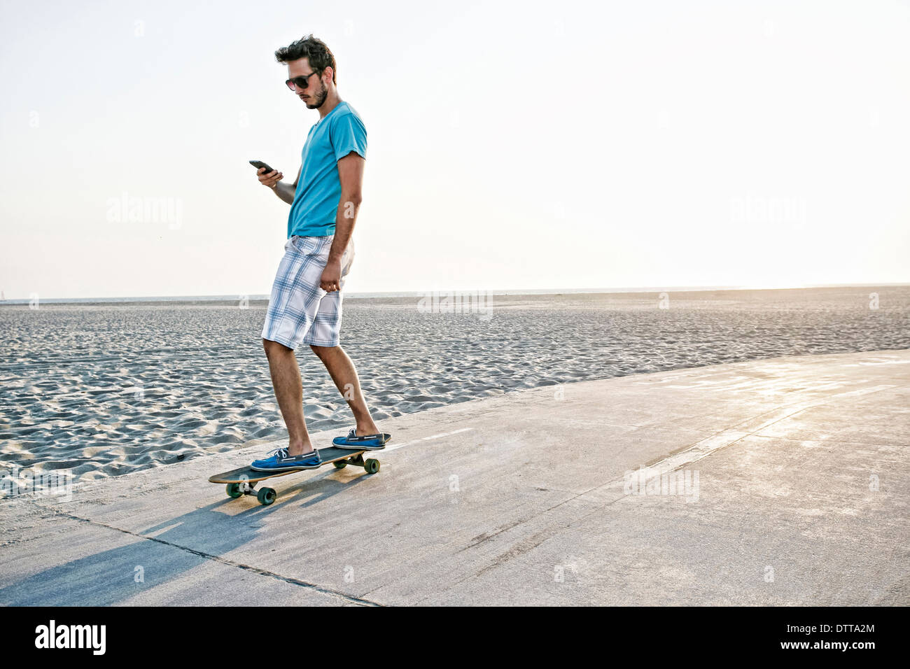 Caucasian man skating on beach Stock Photo - Alamy
