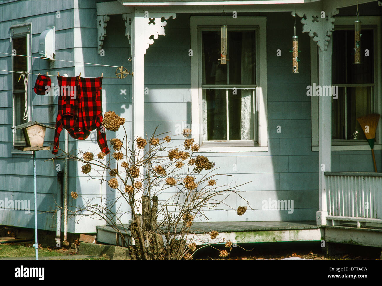 Black and red checkered hunting shirt and cap hang off porch ...