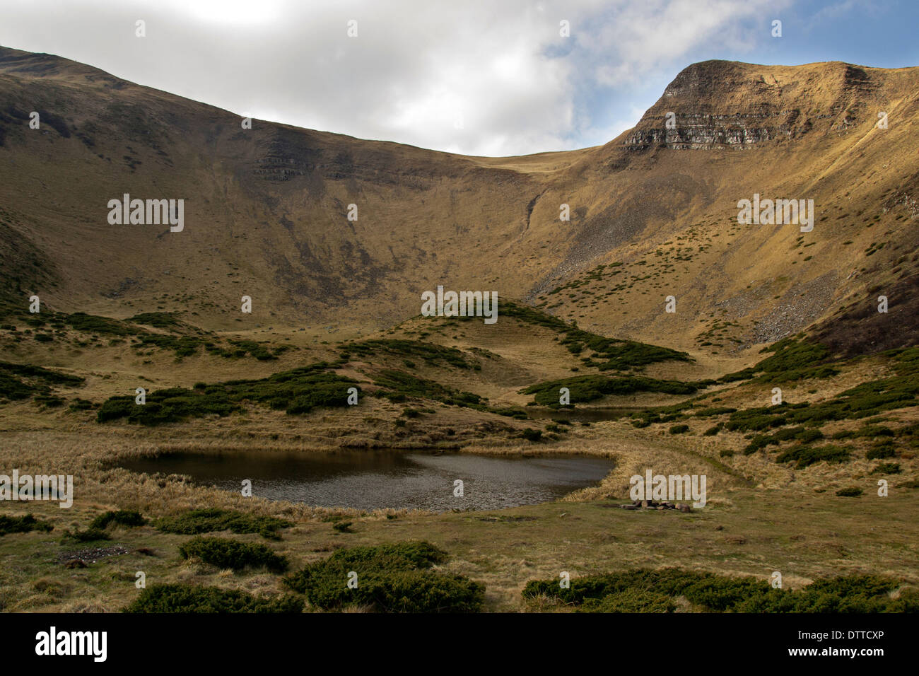 Oval lake at the foot of the mountain Stock Photo - Alamy