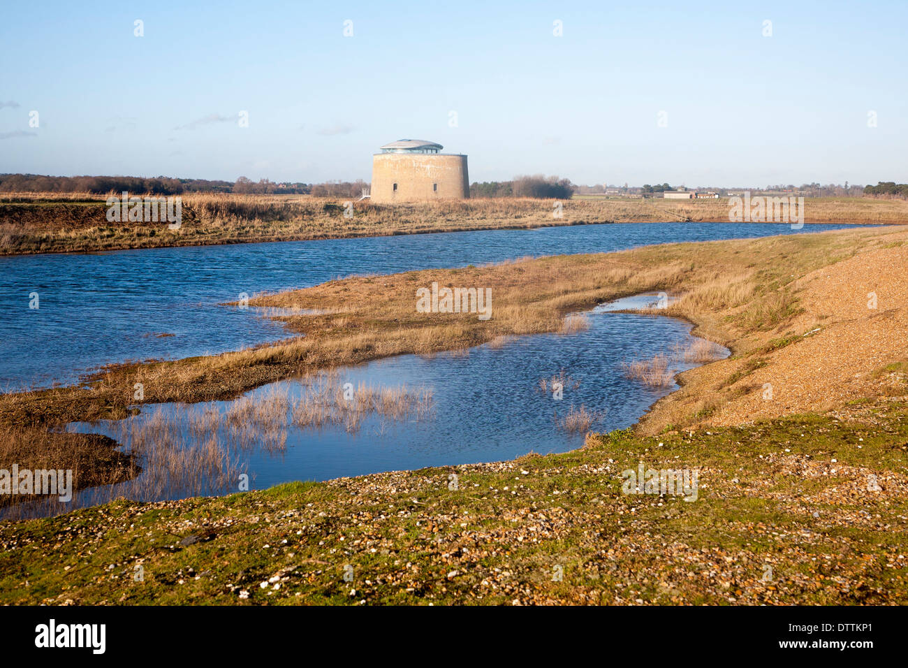 Martello tower standing by coastal defence embankment lagoon of water ...