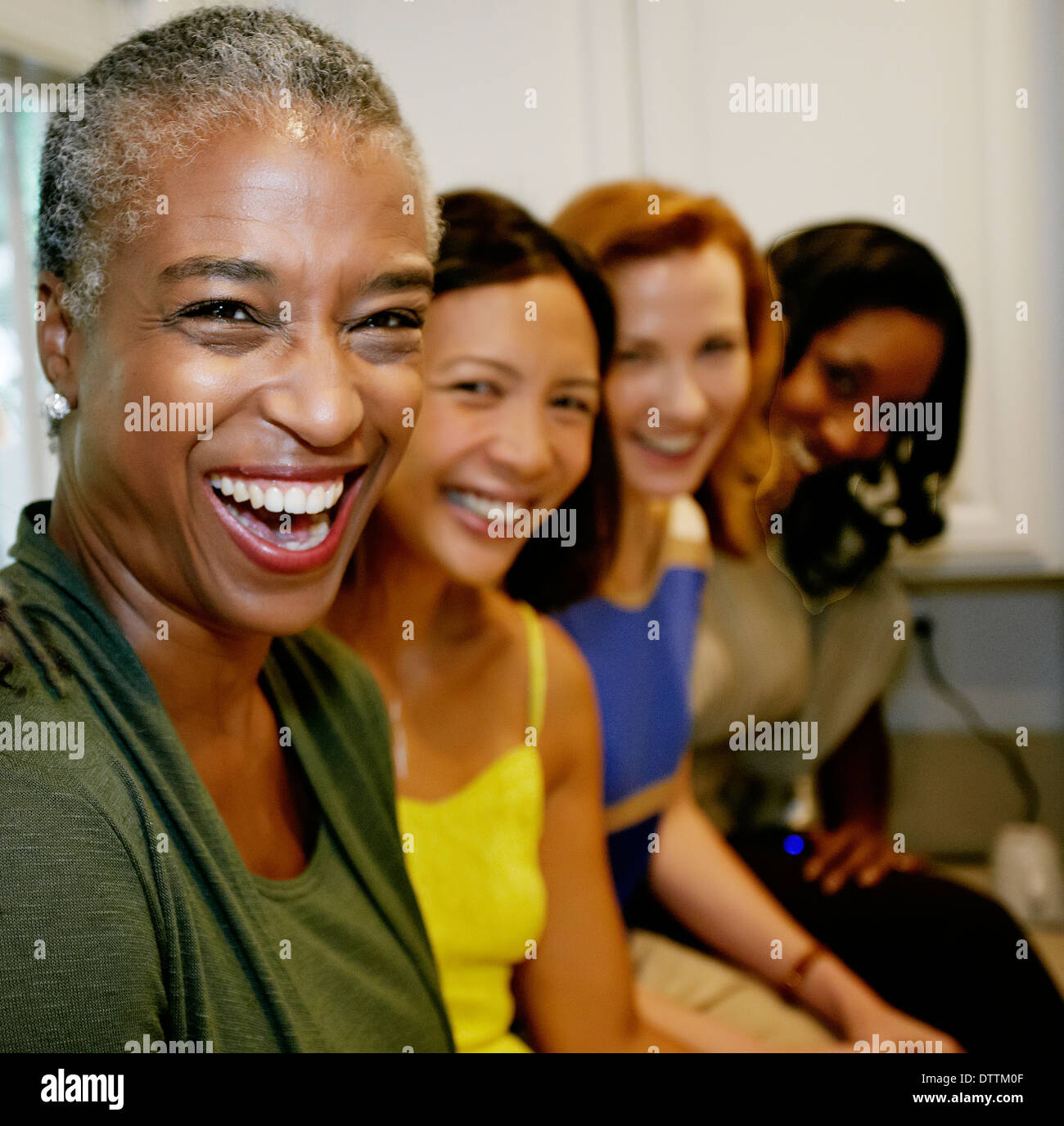 Women laughing together in kitchen Stock Photo - Alamy