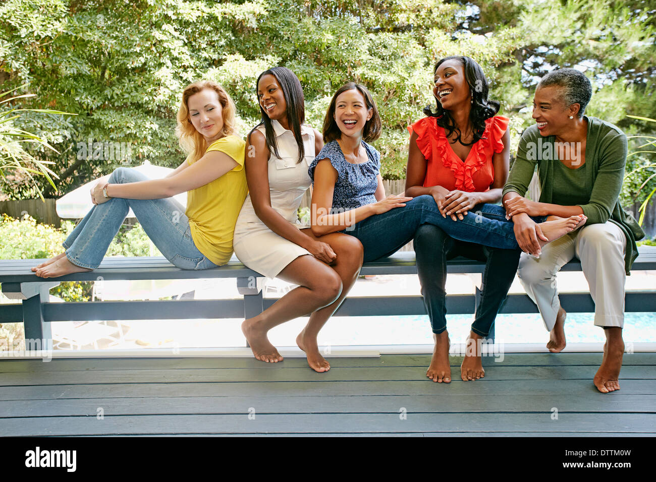 Women smiling together on bench Stock Photo - Alamy